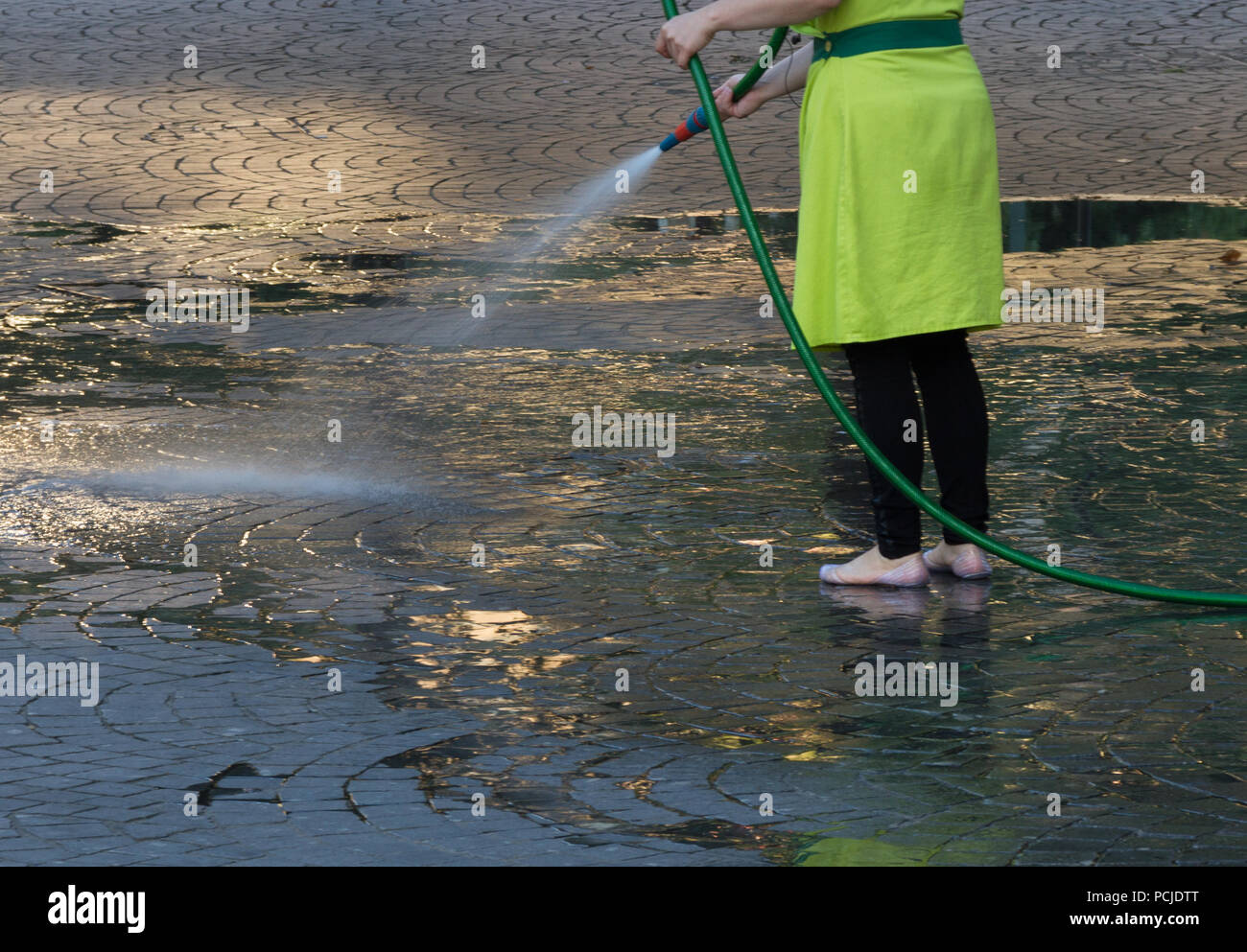 Wet cleaning of street with pressurized water Stock Photo - Alamy
