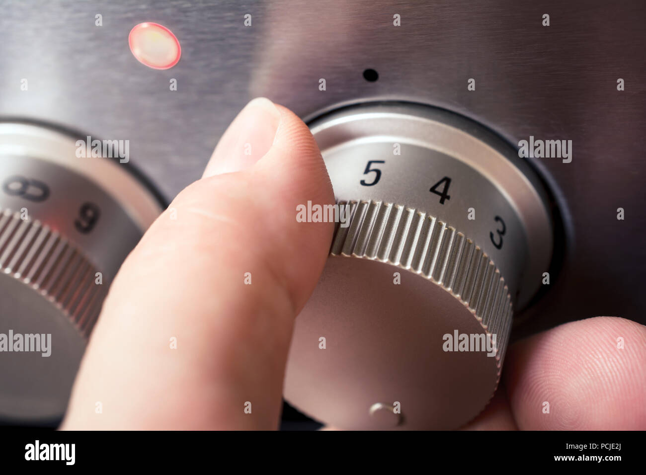 Male Hand Using Stove Controls To Set The Heat Level For A Hotplate ...