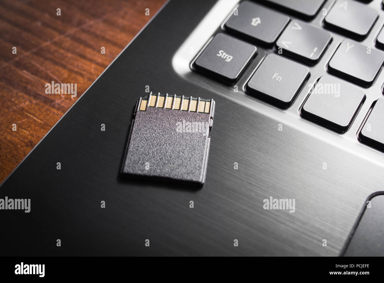 Black SD Card Lying On The Edge Of A Noteook Keyboard On A Table ...