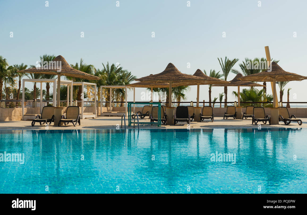 swimming pool and sunbeds at seasore background Stock Photo - Alamy