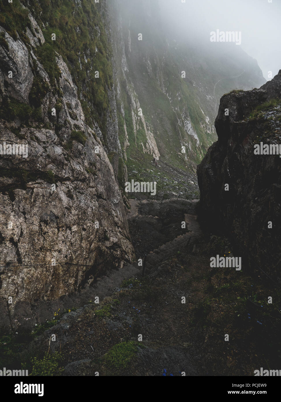 scary steep hiking path with stairs on steep mountain. hiking path sign ...