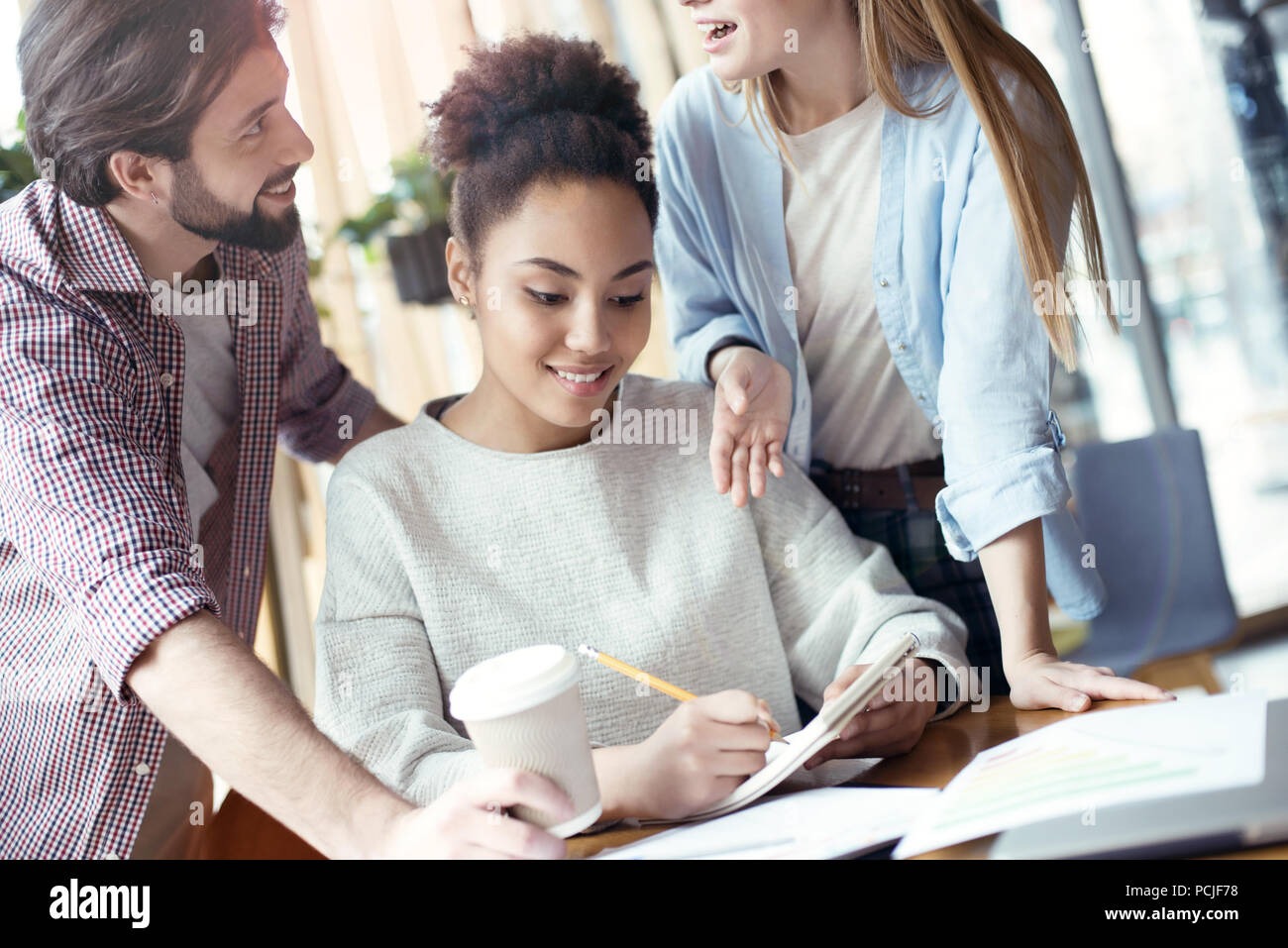 Young people coworking together at creative office sitting takin Stock ...