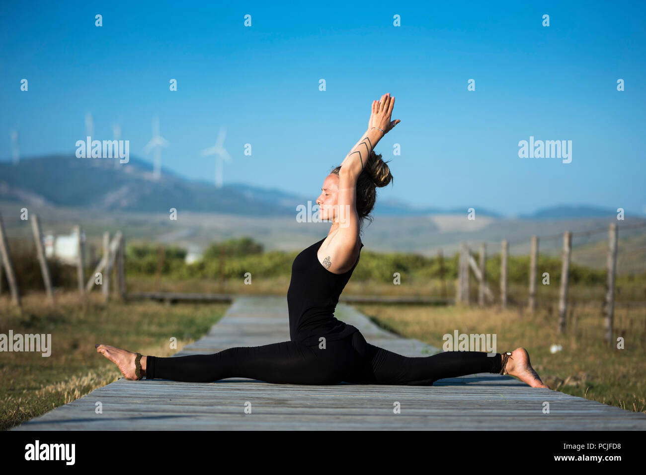 Woman on Los Lances beach doing front splits yoga pose, The Strait ...