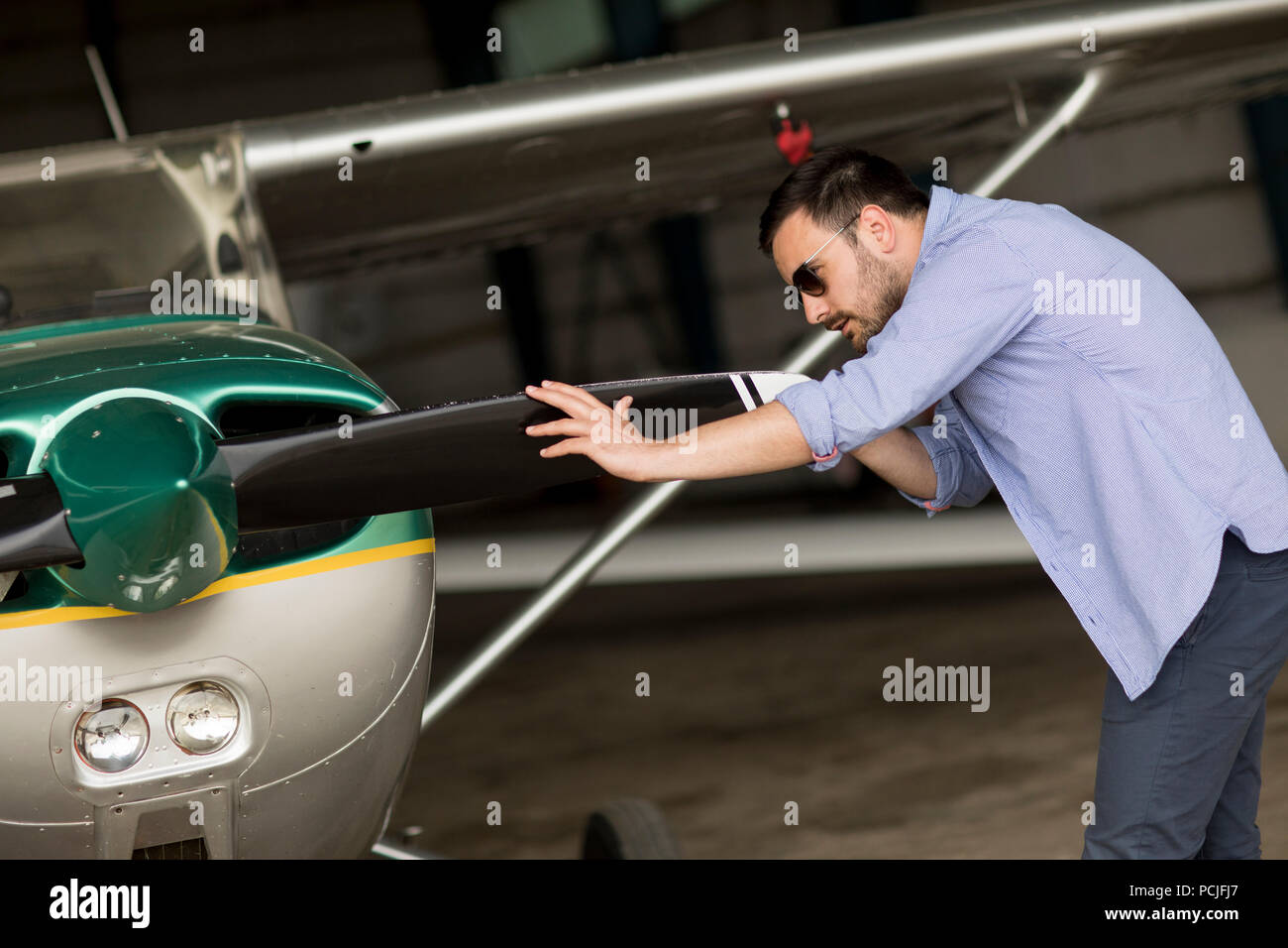 Handsome young pilot checking ultralight airplane before flight Stock ...
