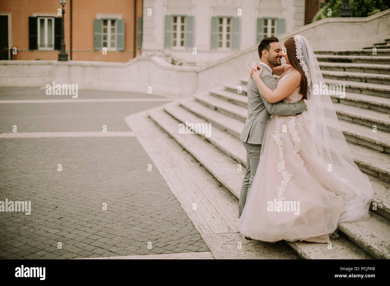 Young attractive newly married couple posing in Rome with beautiful and ...