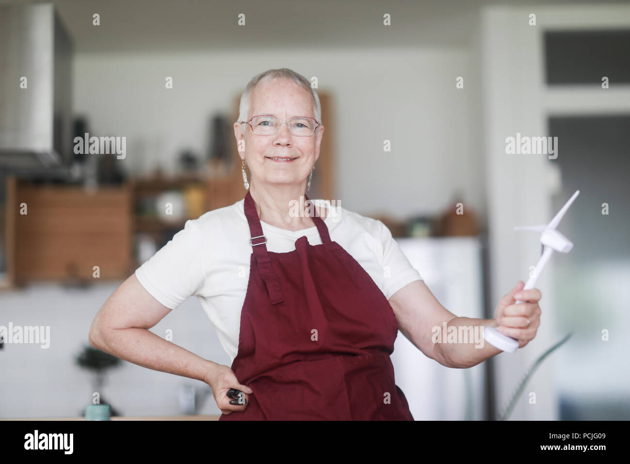 Smiling woman holding an electric fan that she's fixed Stock Photo - Alamy