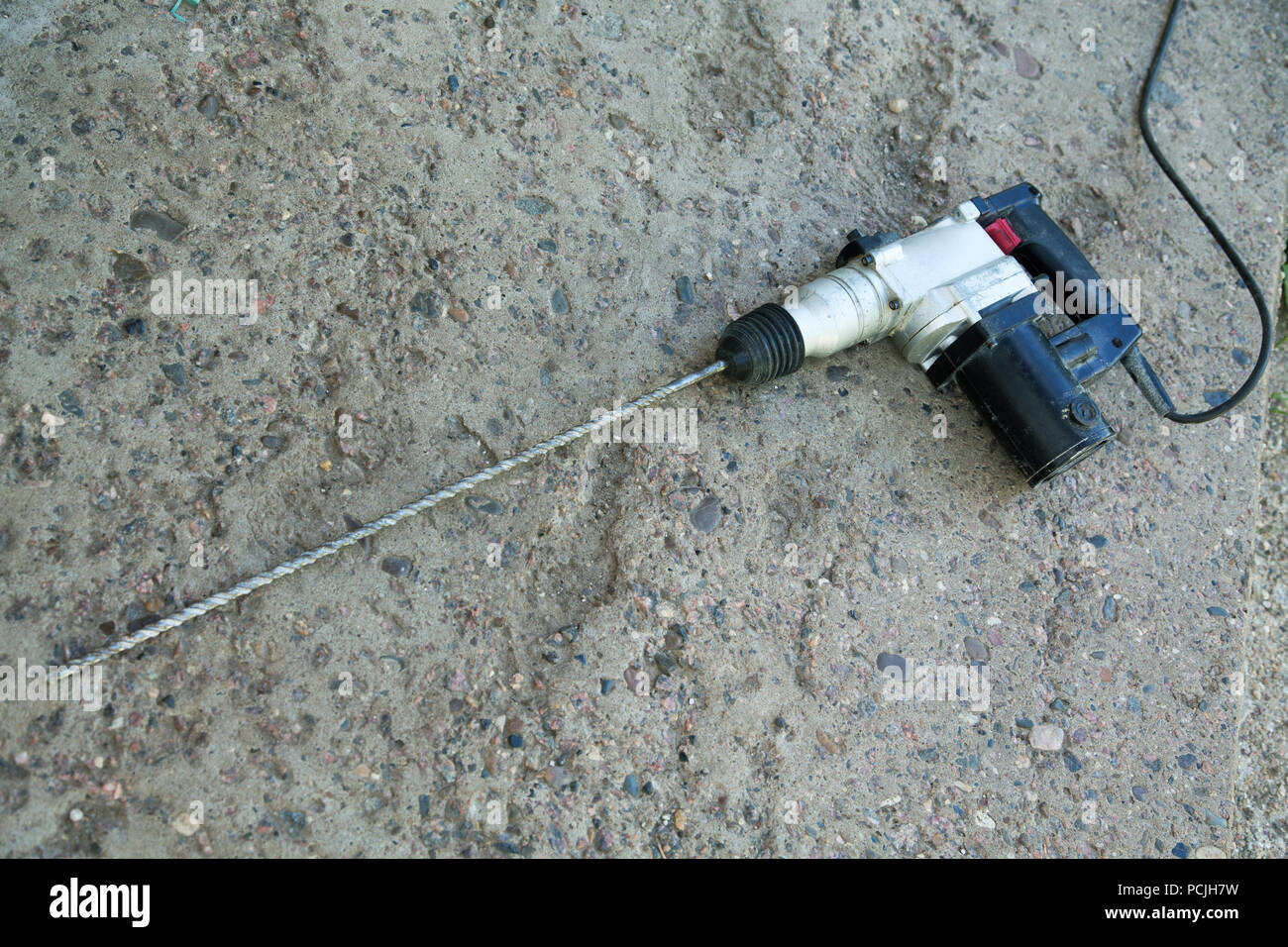 perforator with a long drill rests on a concrete surface Stock Photo ...