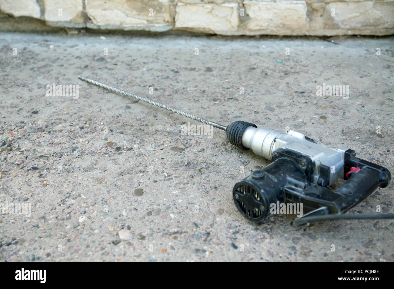 perforator with a long drill rests on a concrete surface Stock Photo ...