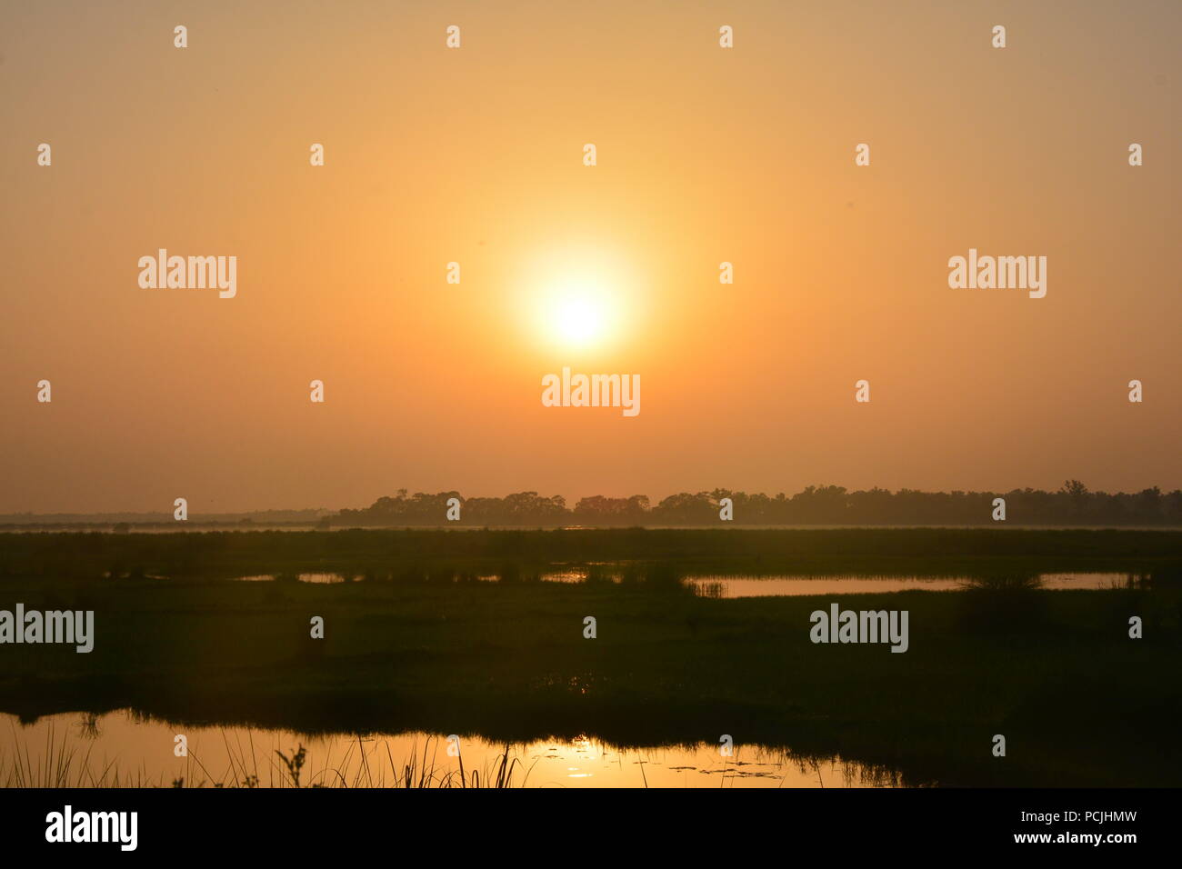 sun setting above river Stock Photo - Alamy