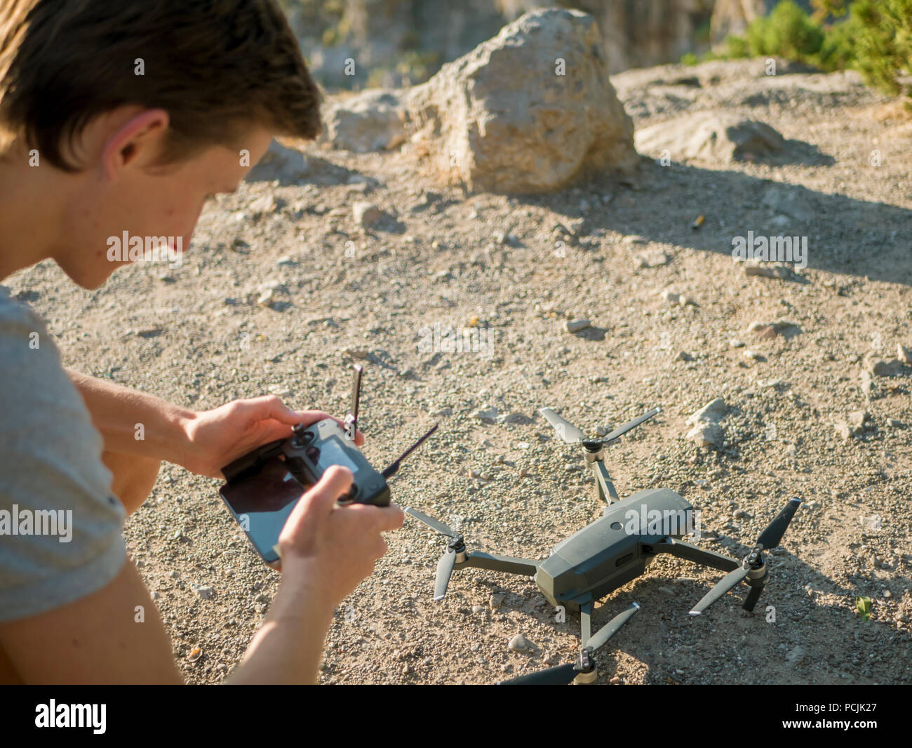 back of man holding controller and control drone take off on the ...