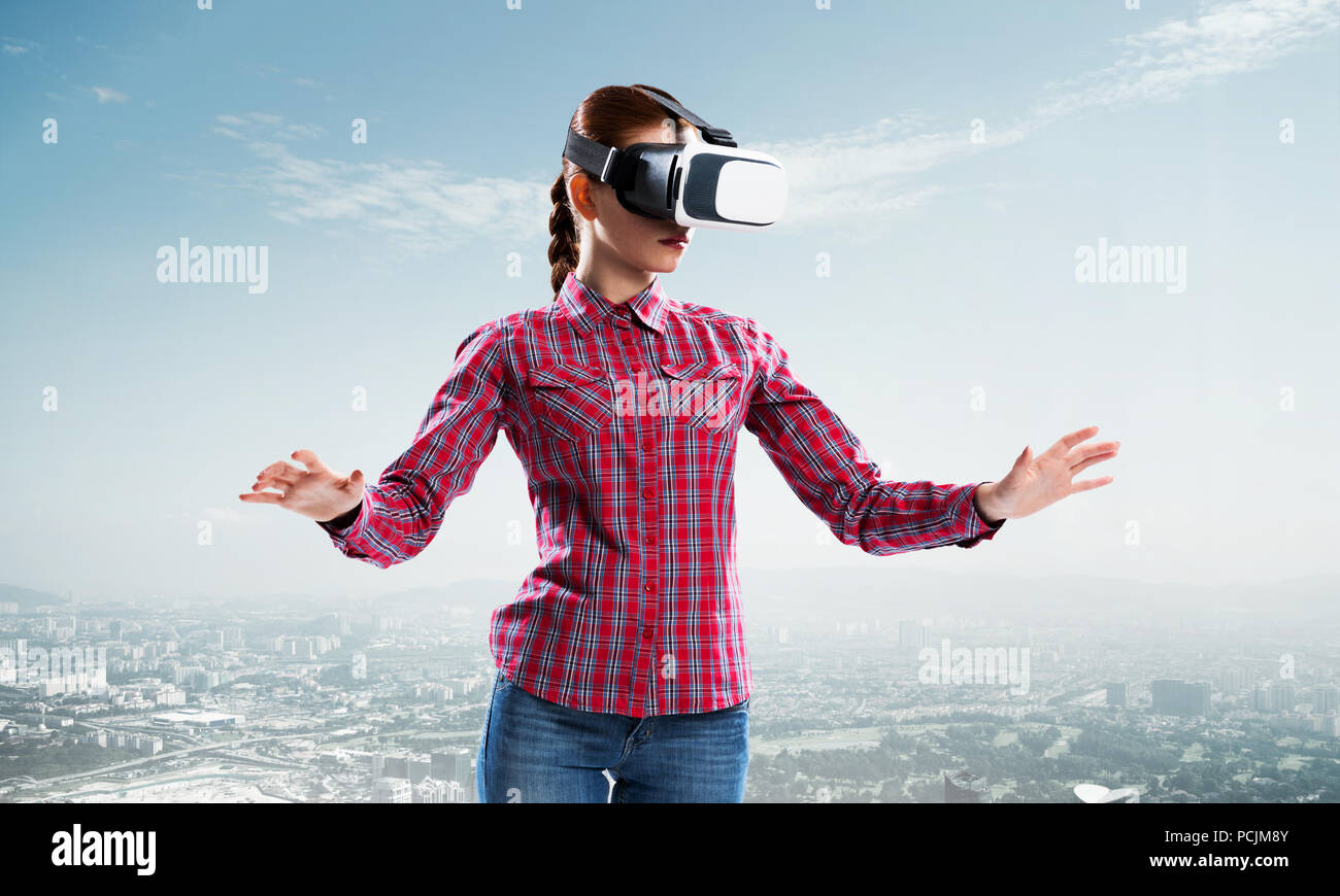 Girl in checked shirt wearing VR glasses experiencing another reality ...