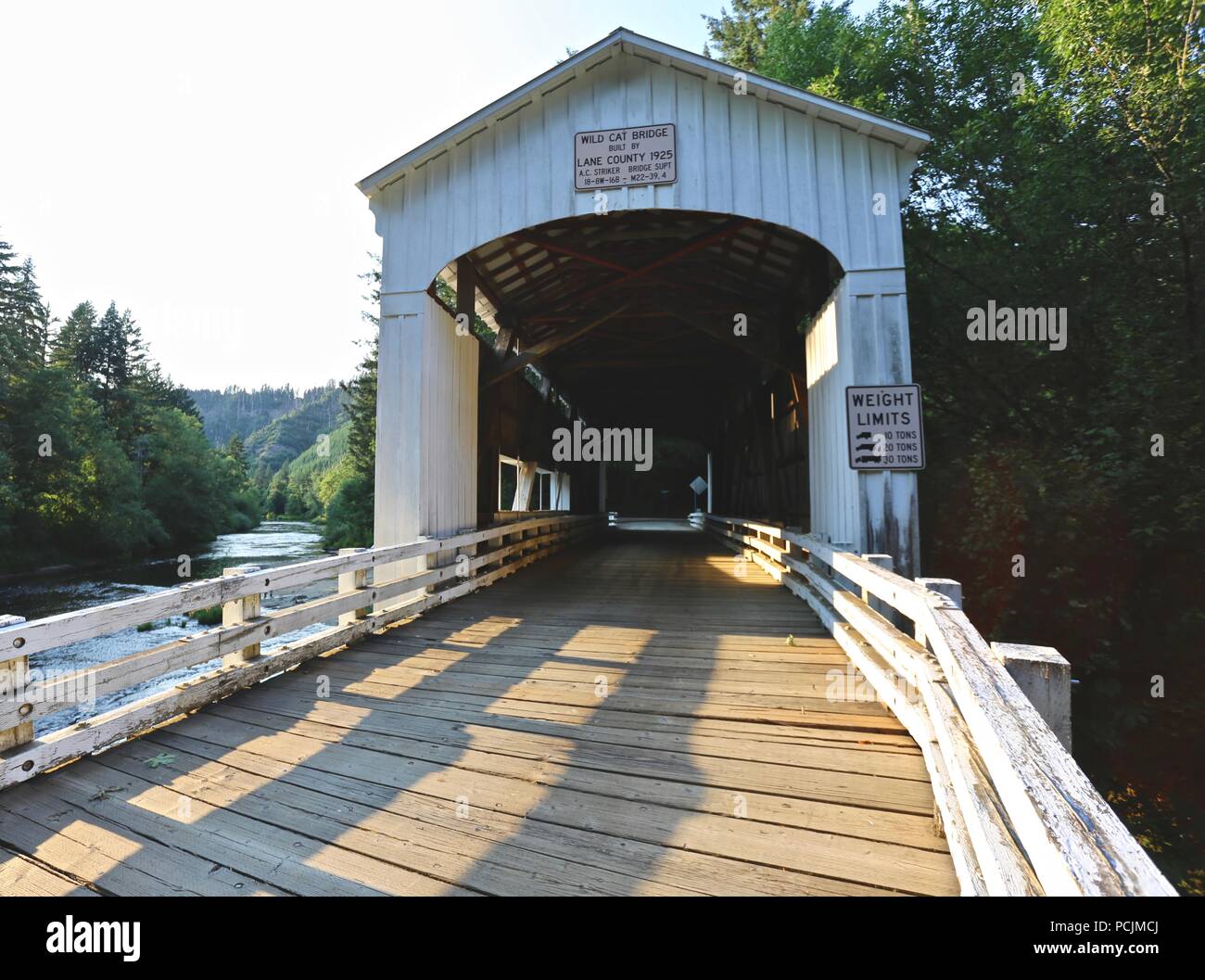 White covered bridge with stream and forest Stock Photo - Alamy