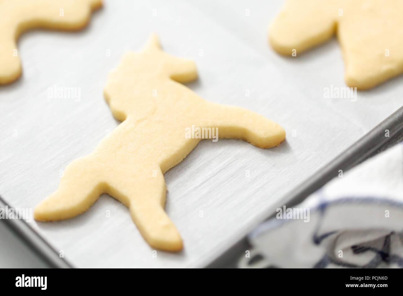 Unfinished unicorn shape sugar cookies on the baking sheet Stock Photo ...