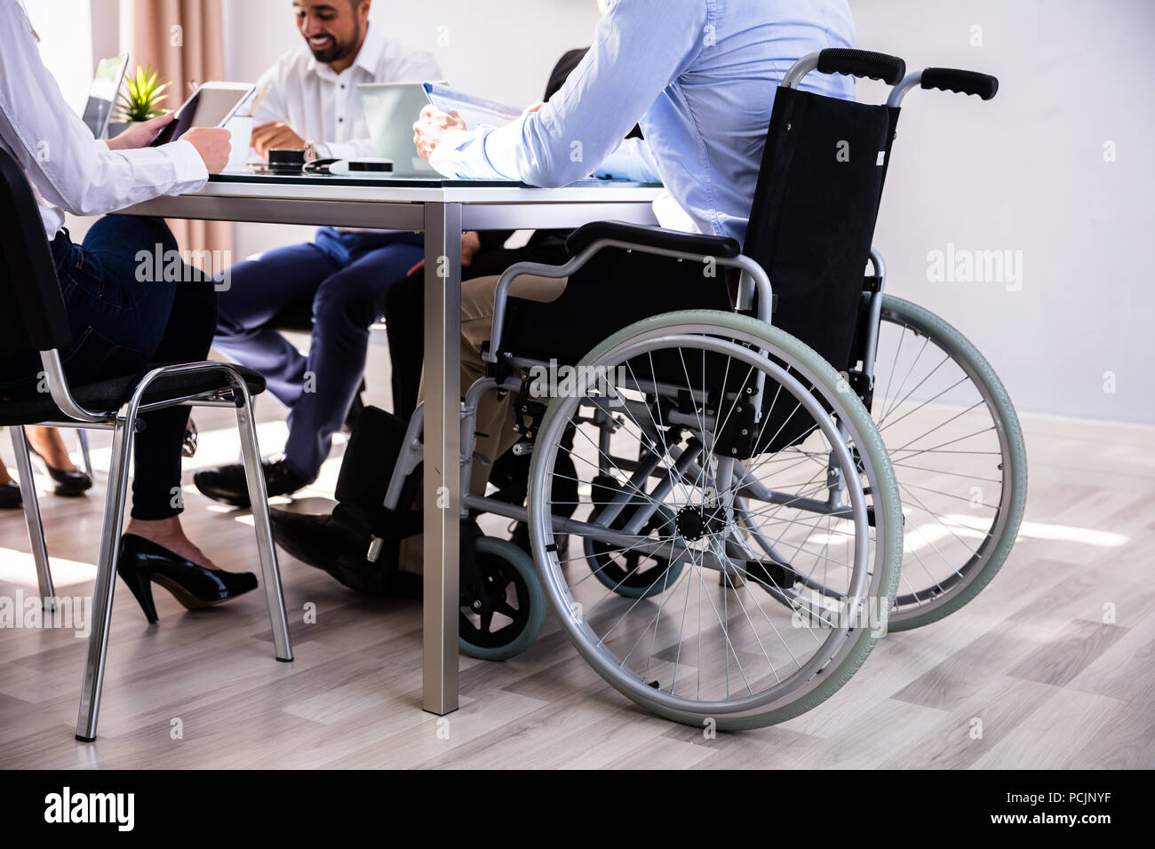 Disabled Businessman Sitting With His Colleagues In Office Stock Photo ...