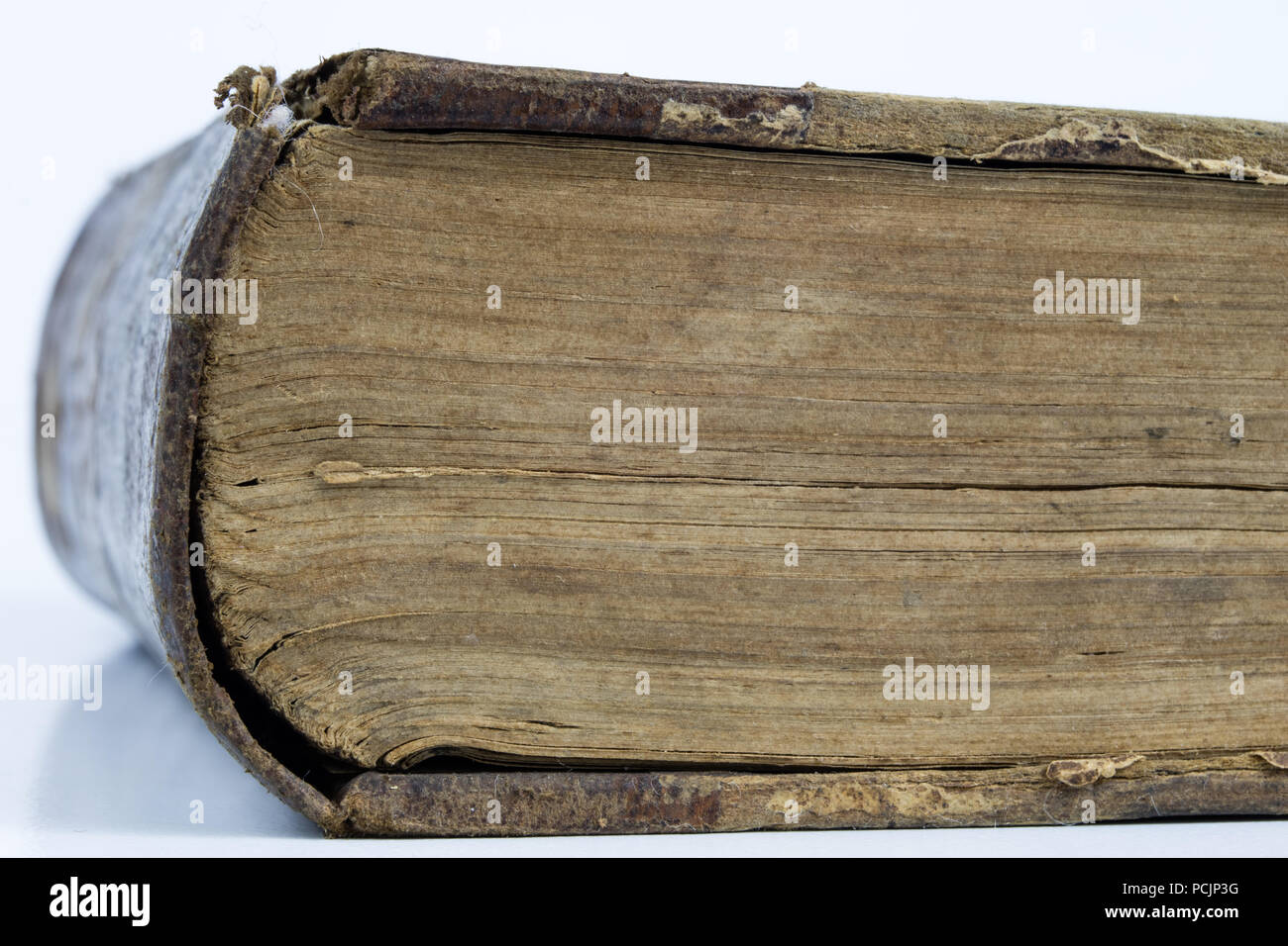Old destroyed book on a white table. Cards and the back of an old ...
