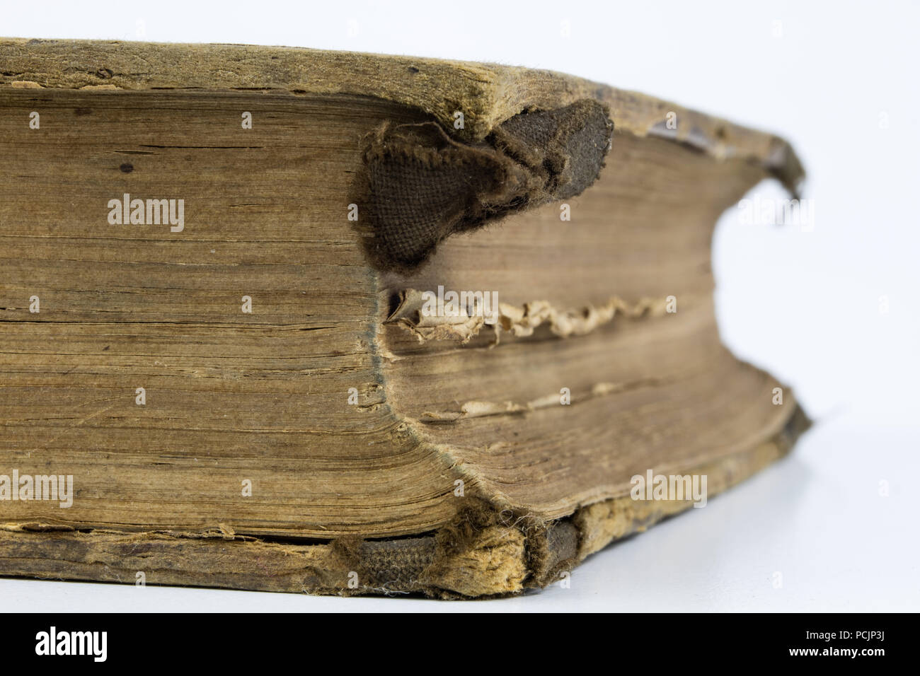 Old destroyed book on a white table. Cards and the back of an old ...