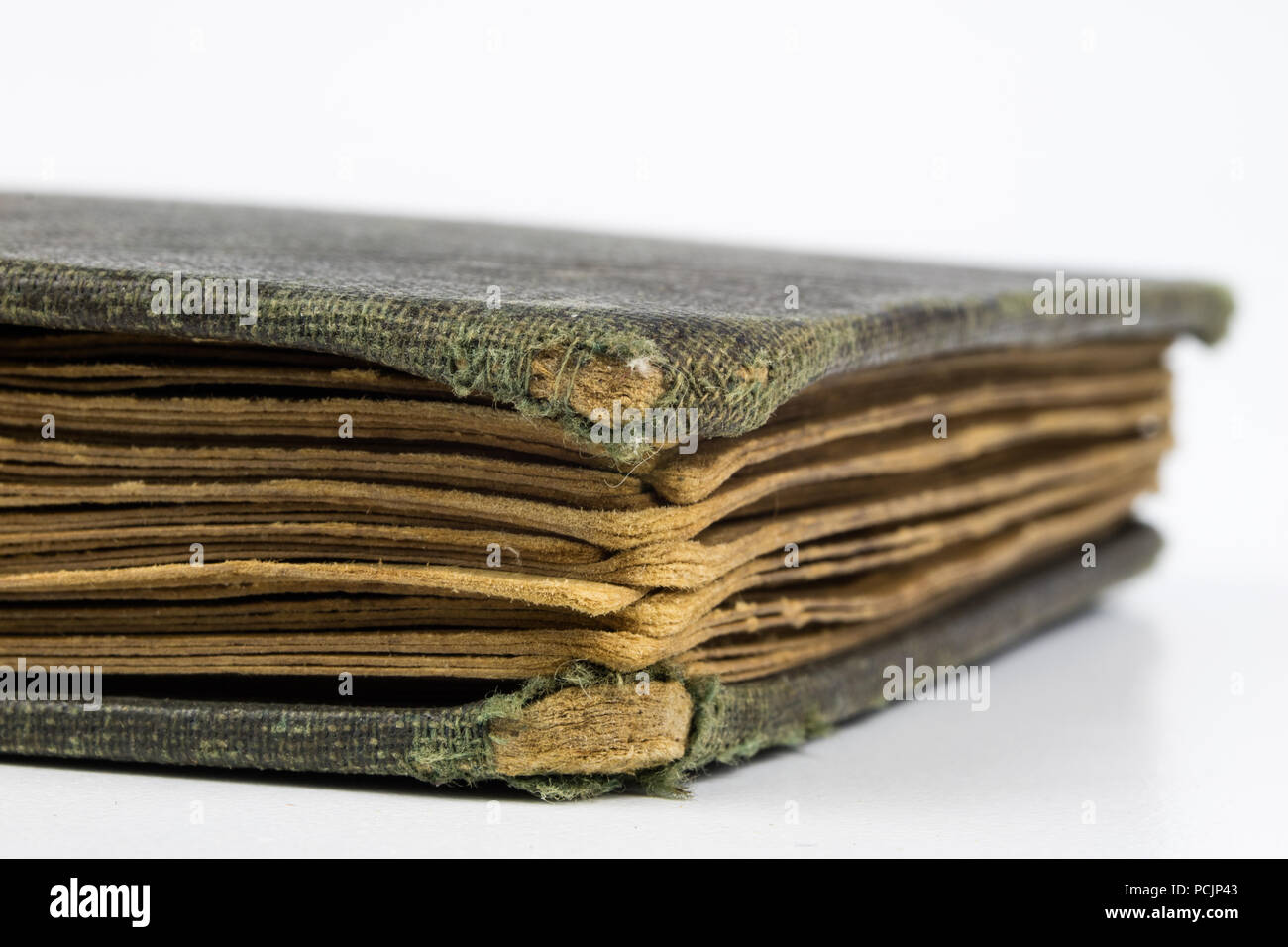 Old destroyed book on a white table. Cards and the back of an old ...