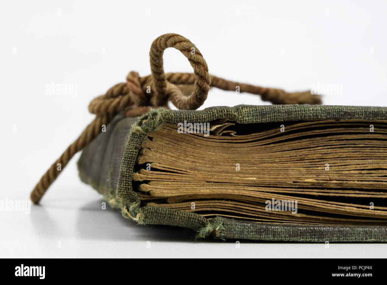 Old destroyed book on a white table. Cards and the back of an old ...