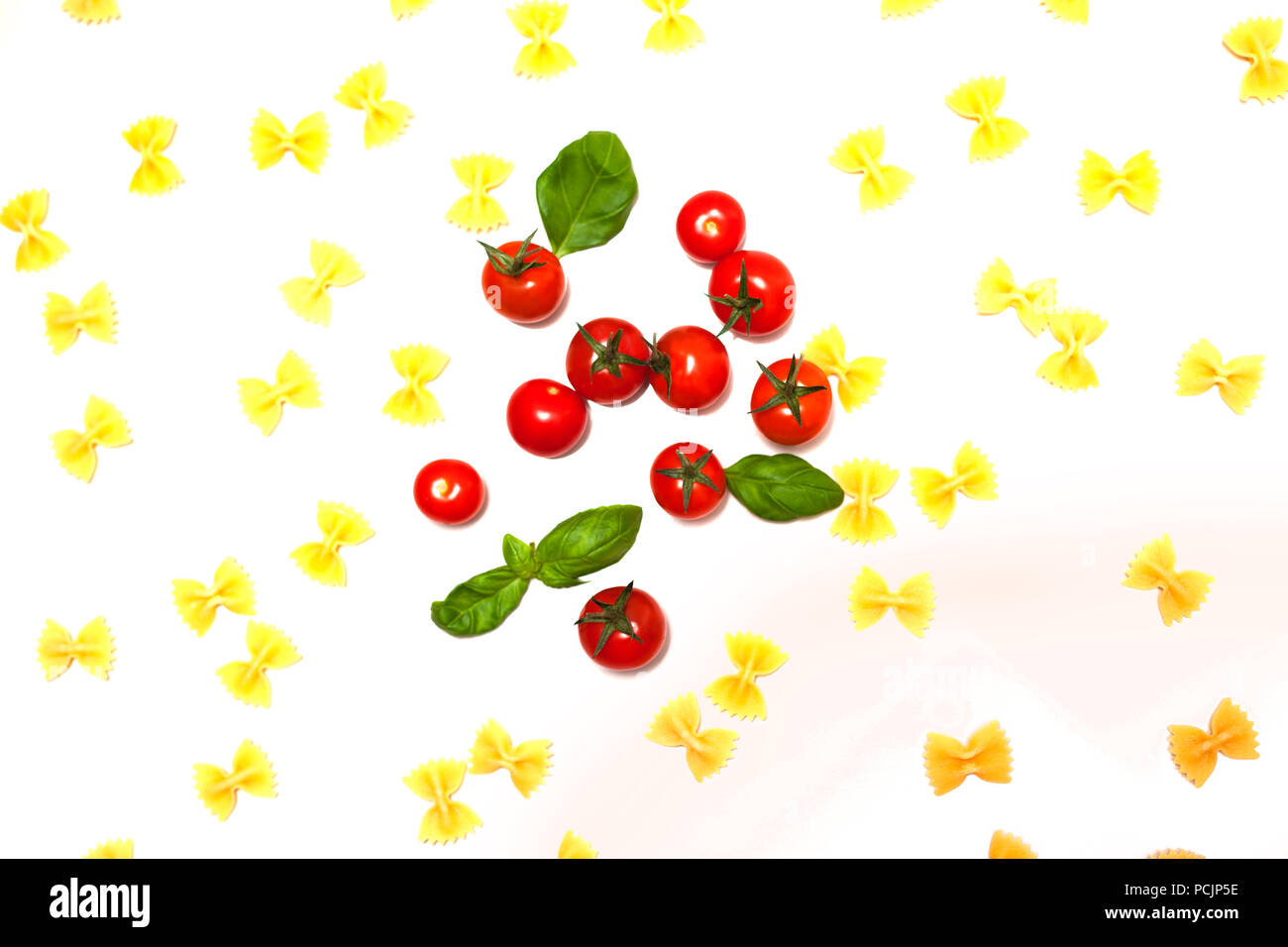 Isolated fresh red and orange cherry tomatoes with green leafs of basil ...