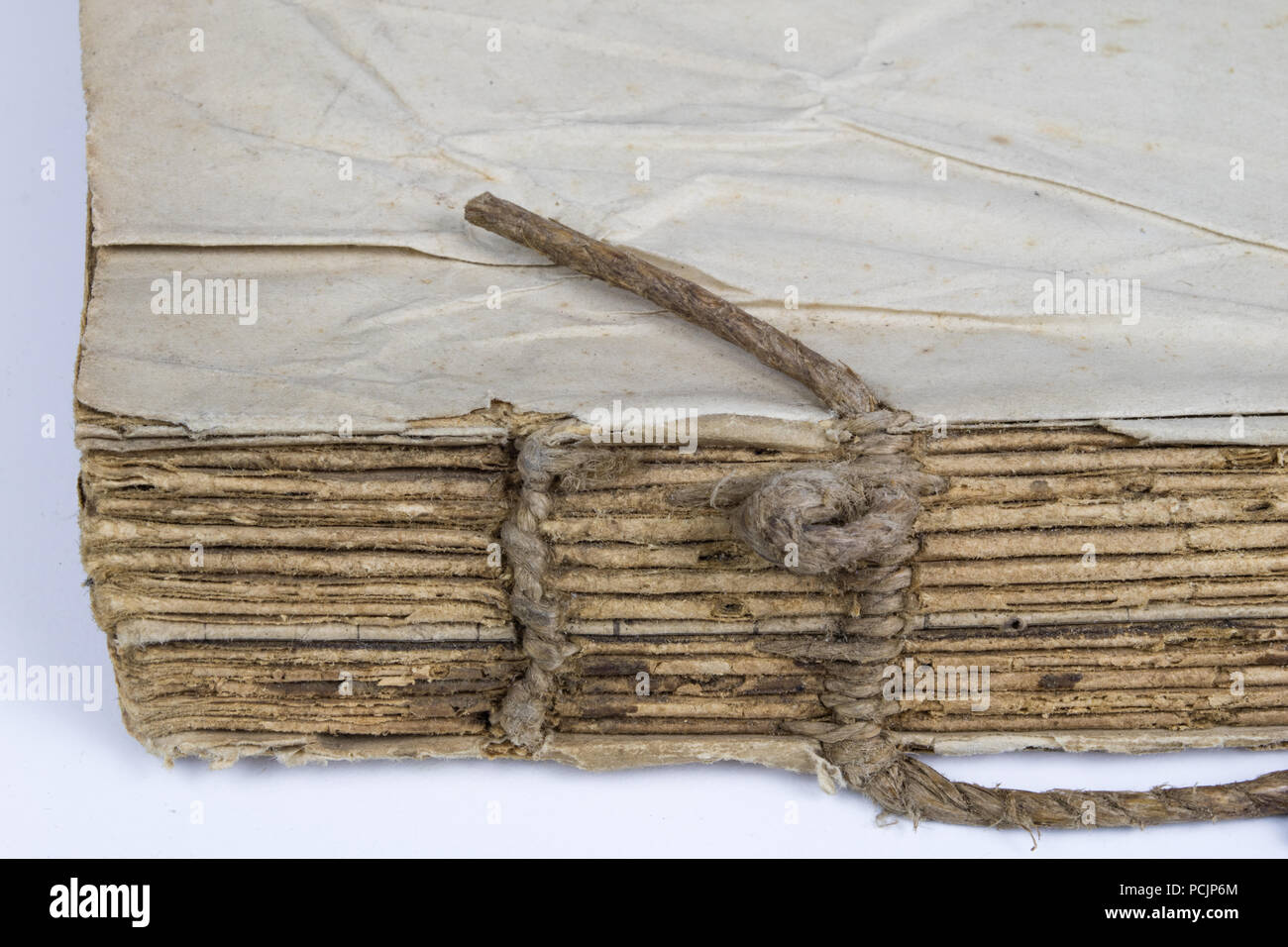 Old destroyed book on a white table. Cards and the back of an old ...