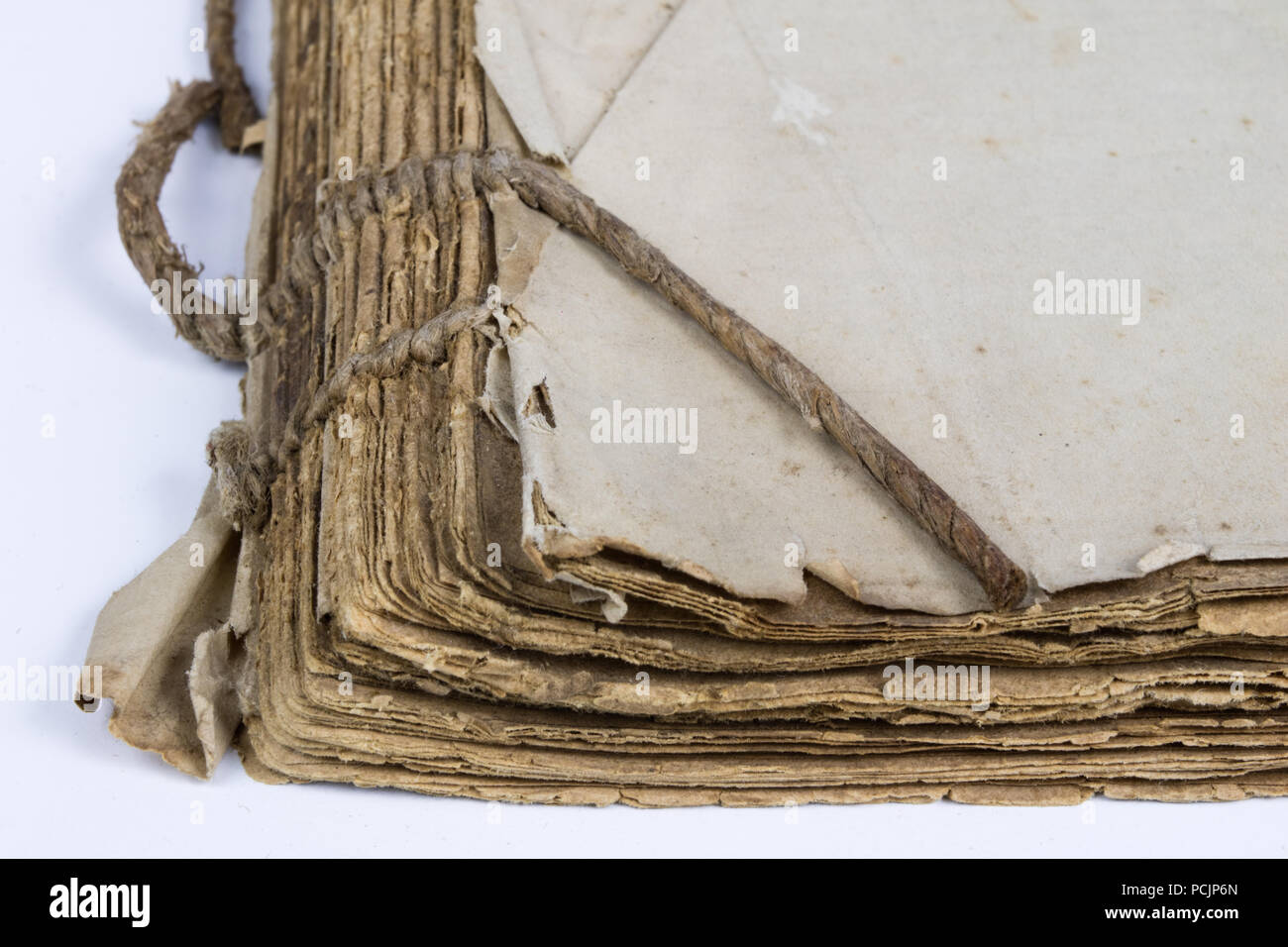 Old destroyed book on a white table. Cards and the back of an old ...