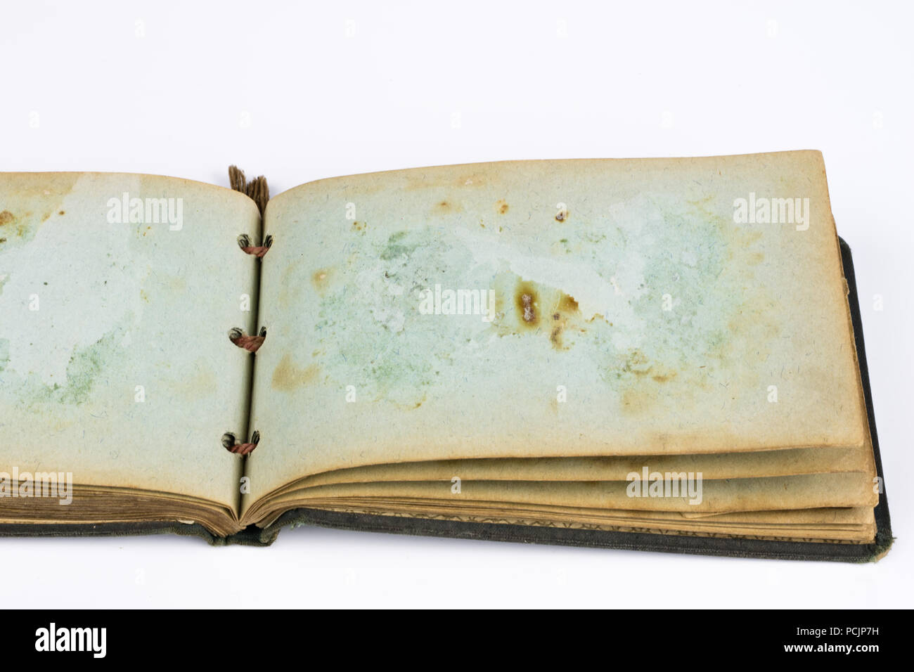 Old destroyed book on a white table. Old-style cover. White isolated ...