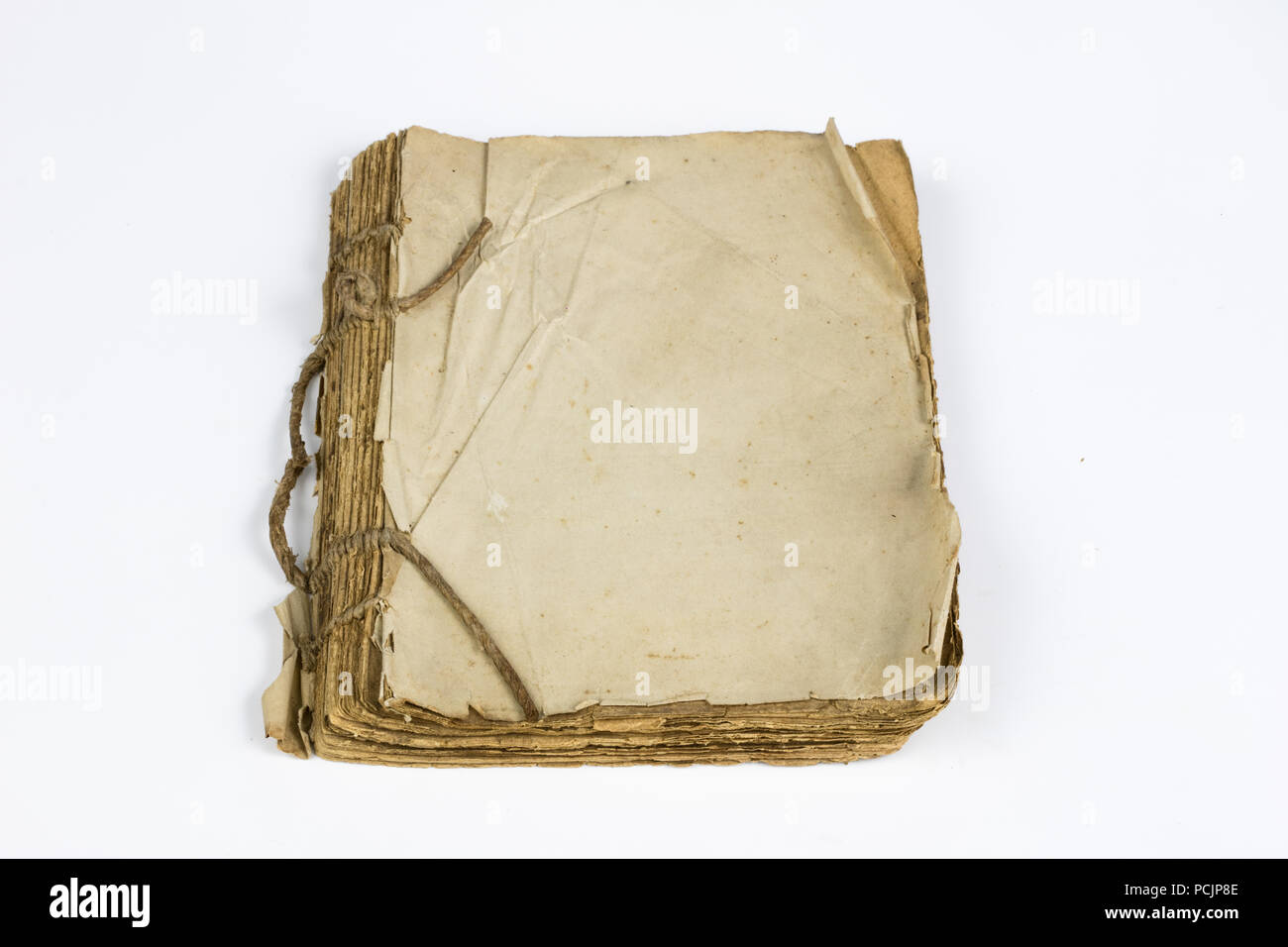 Old destroyed book on a white table. Old-style cover. White isolated ...