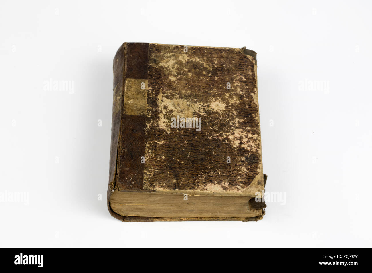 Old destroyed book on a white table. Old-style cover. White isolated ...