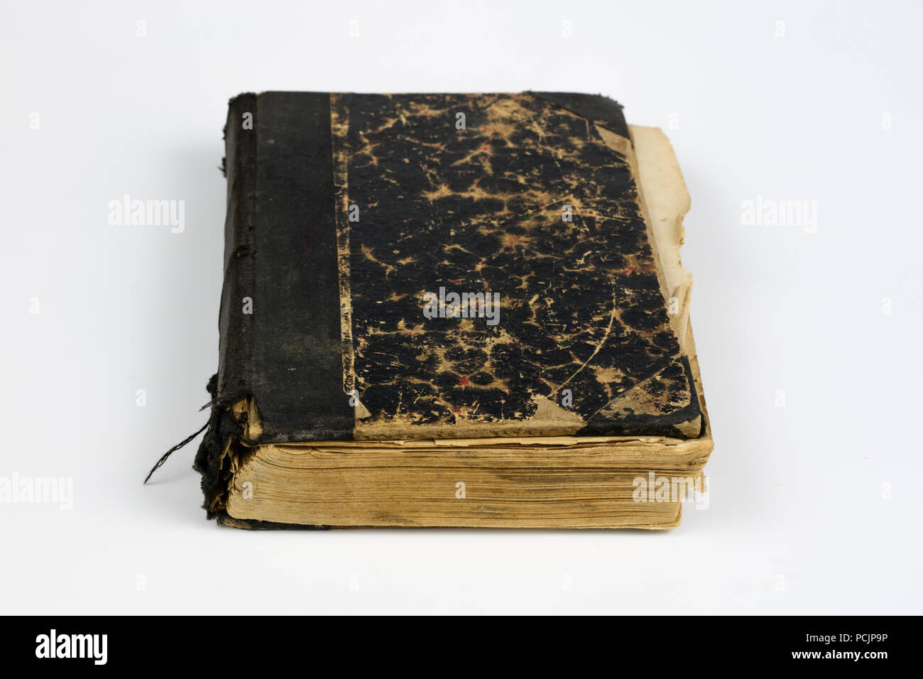 Old destroyed book on a white table. Old-style cover. White isolated ...