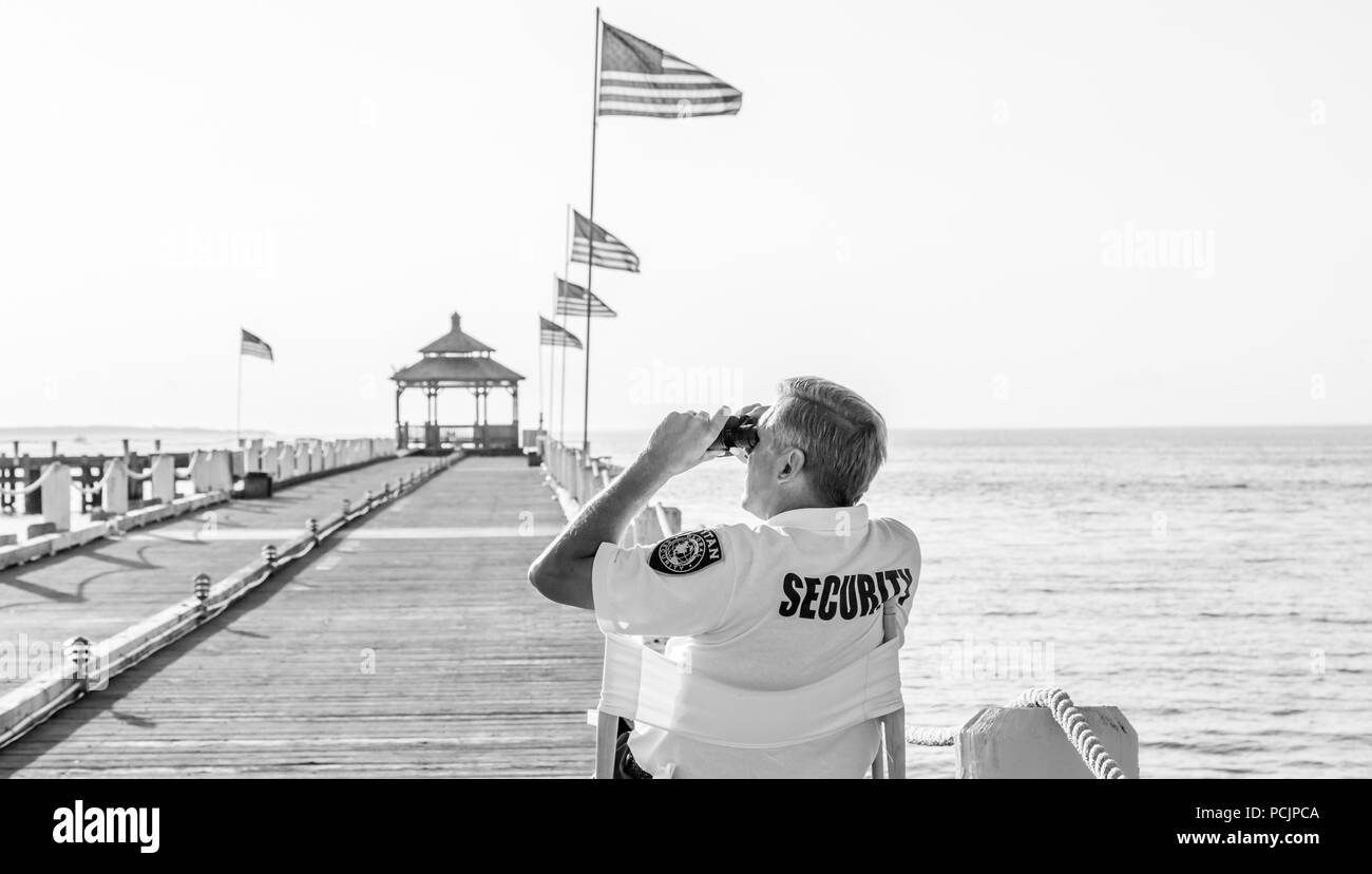 Security guard sitting on chair Black and White Stock Photos & Images ...
