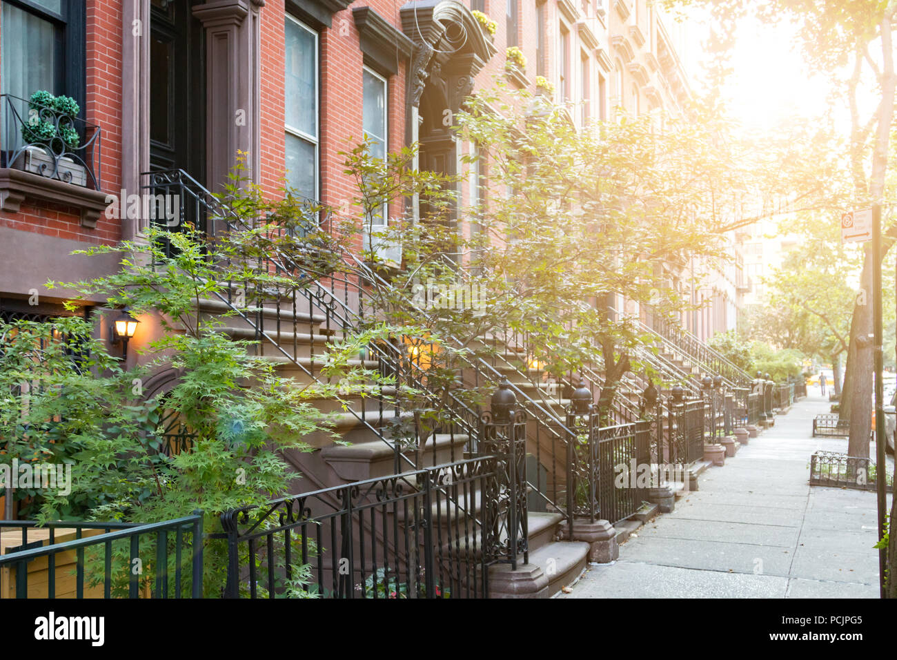 Sunlight shines on historic brownstone buildings in Manhattan New York ...