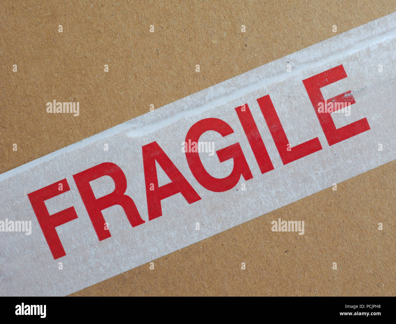 fragile warning tape on brown corrugated cardboard Stock Photo - Alamy