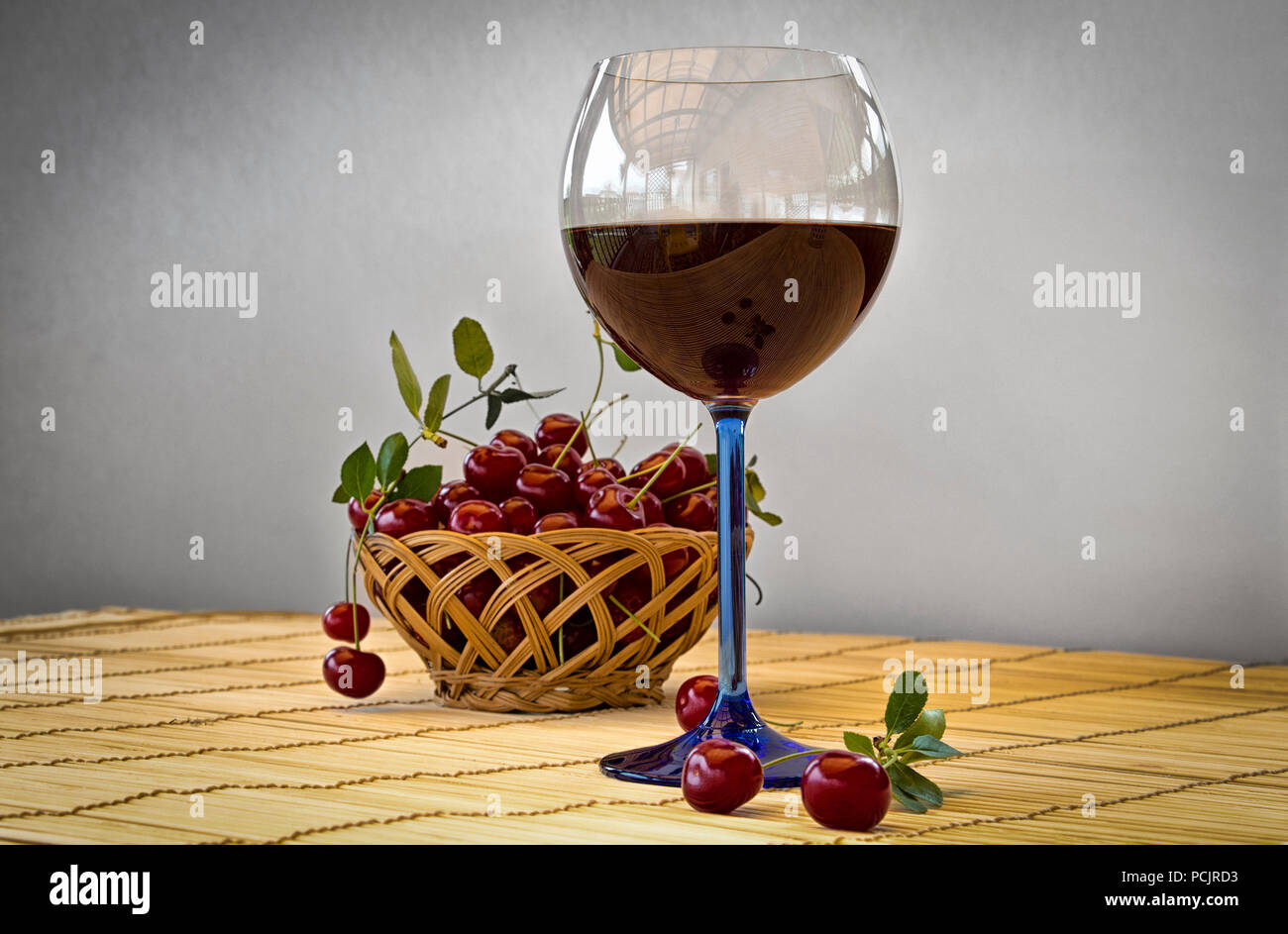 A glass of red wine and cherry berries on a wooden table close up Stock ...