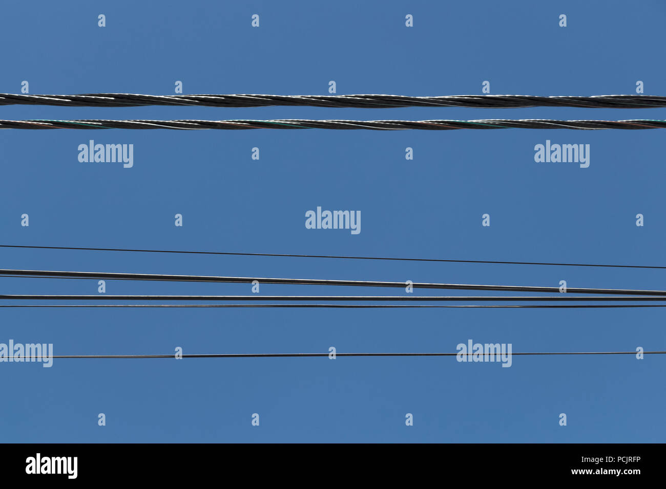 A line of electric wires close-up against a blue sky Stock Photo - Alamy