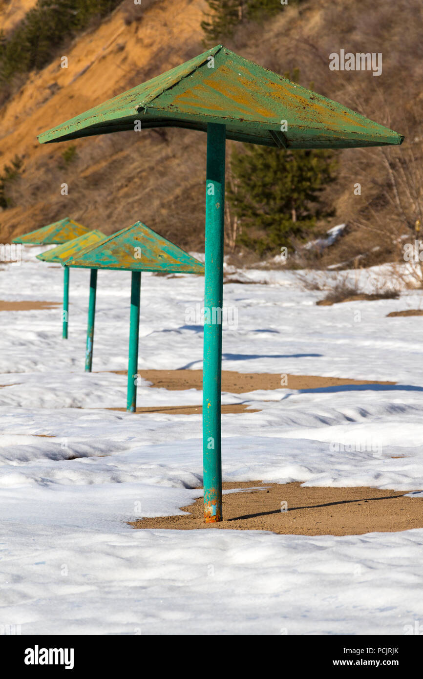 Abandoned rusty beach umbrellas on a beach covered with snow Stock ...