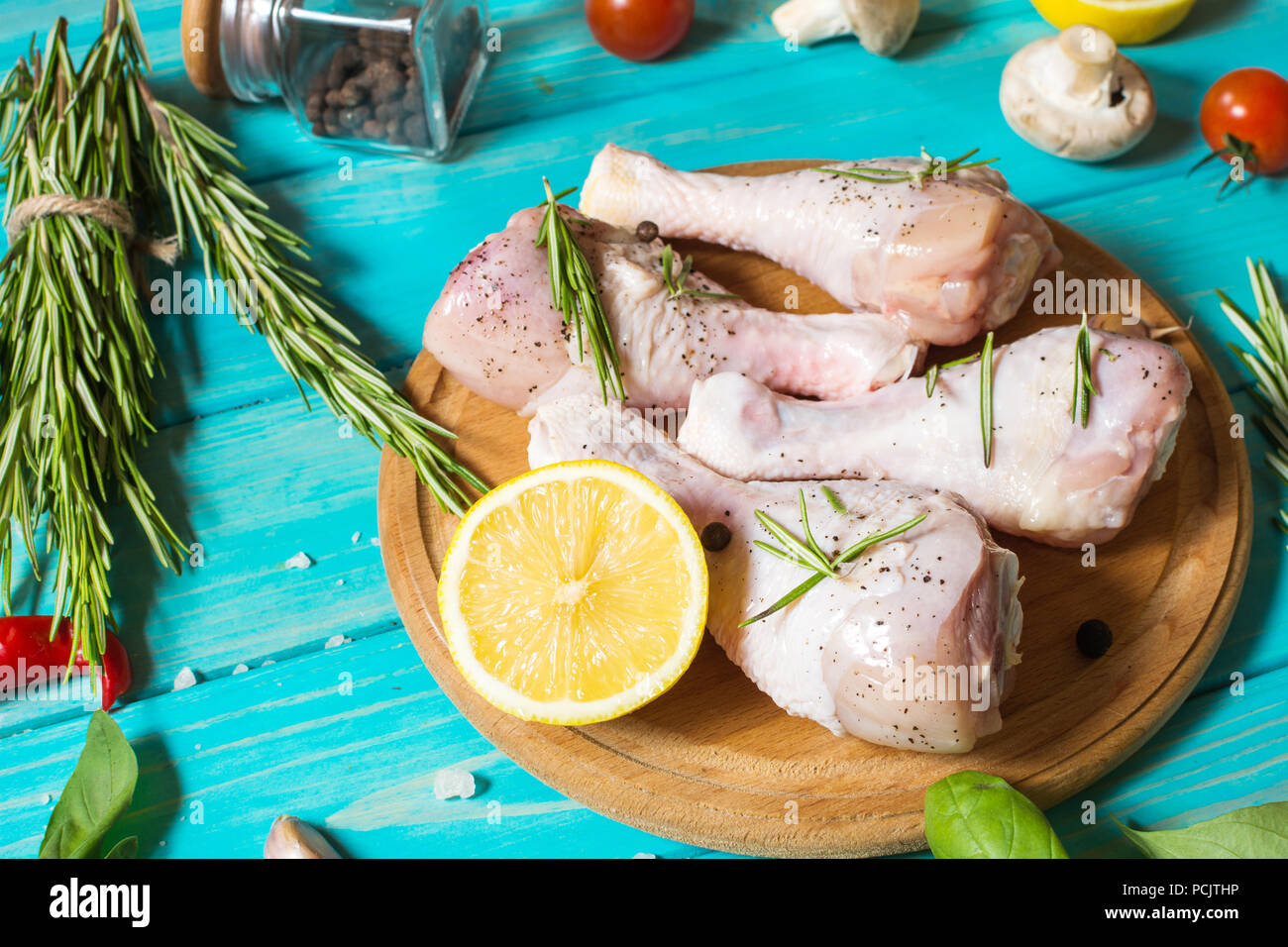 Raw uncooked chicken legs, drumsticks on blue wood background, meat ...
