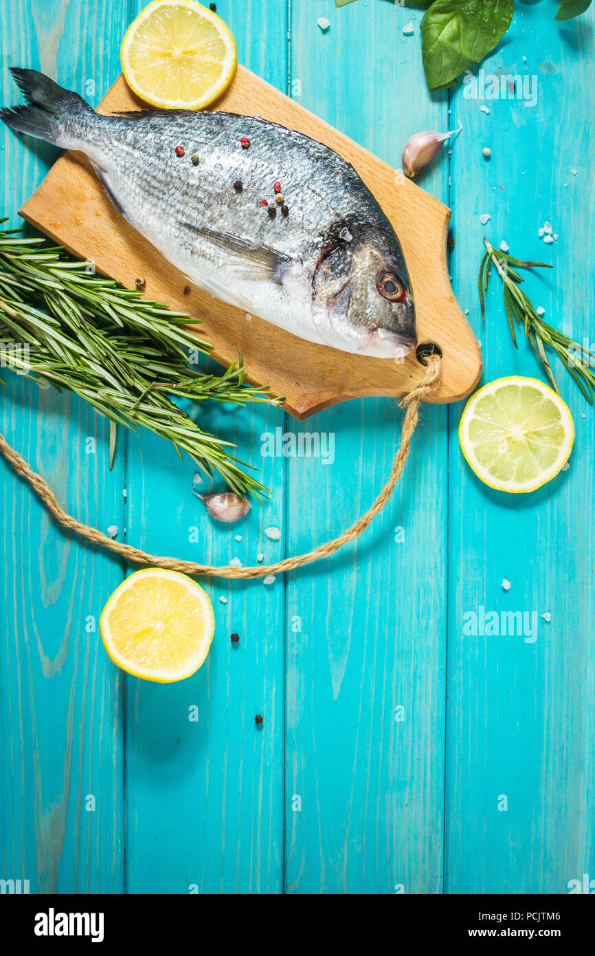 Raw fresh dorado with lemon on blue wood stone background. Top view and ...