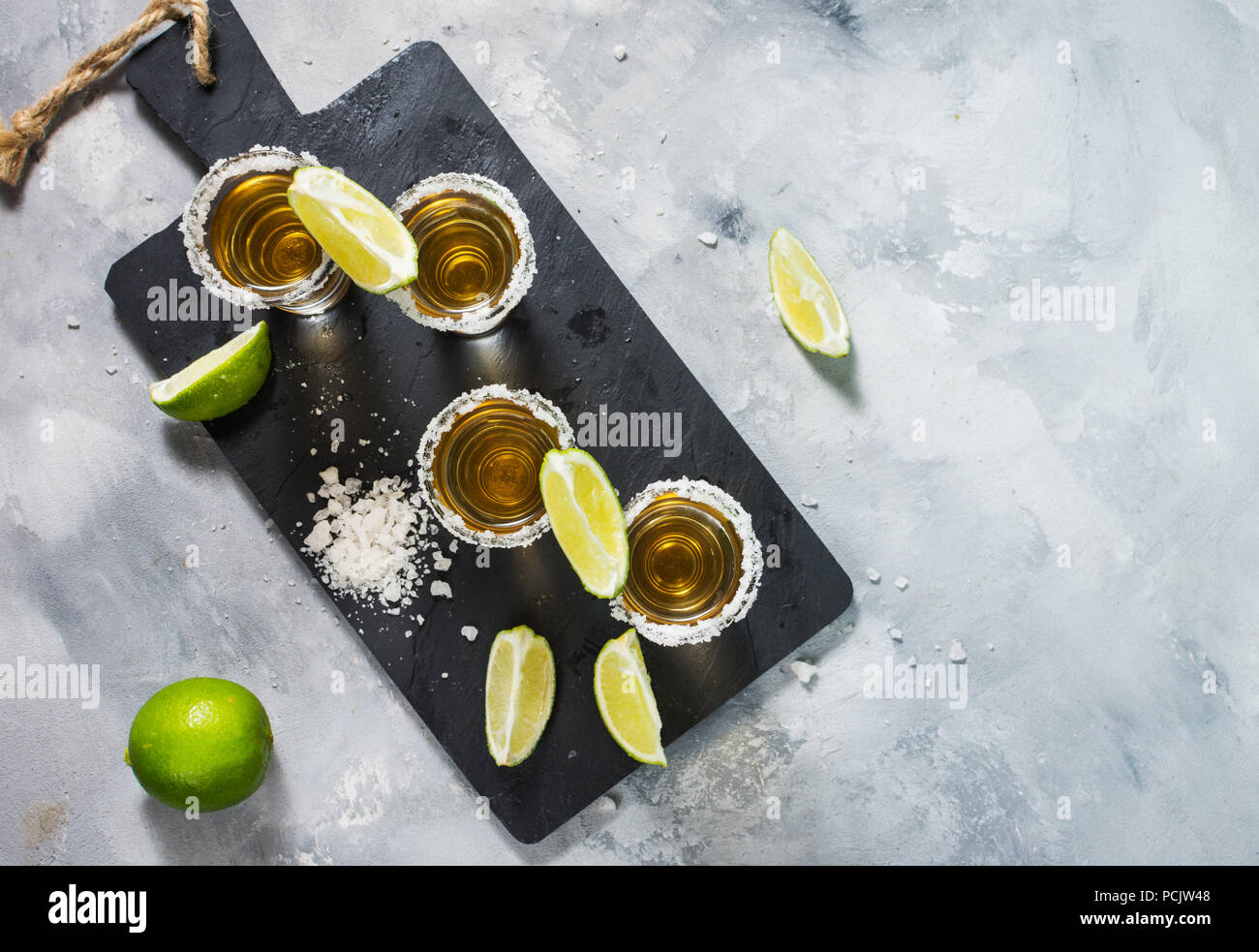Mexican gold tequila with lime and salt on black stone background. Top ...