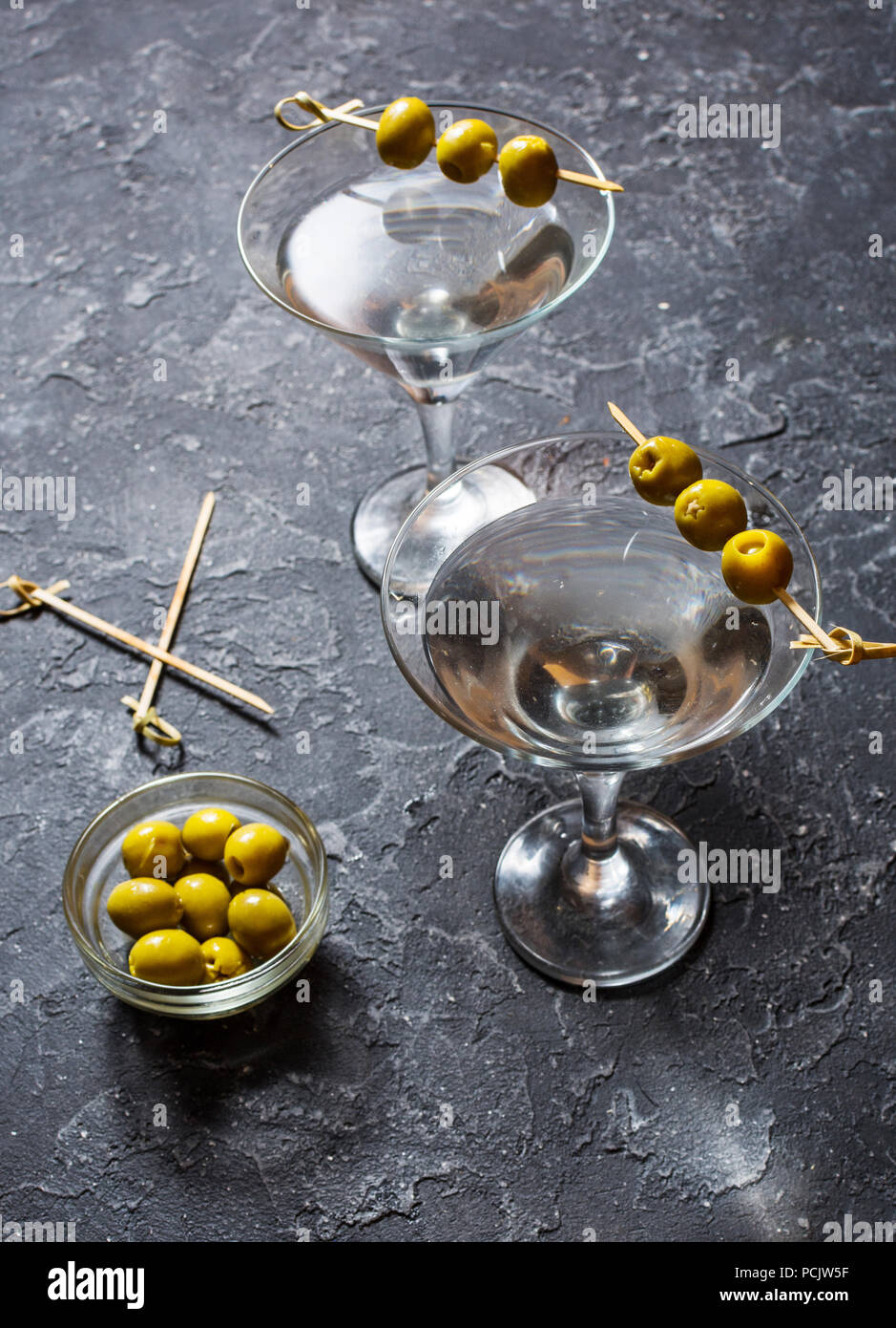 Martini cocktail with green olives on stone table background Stock ...