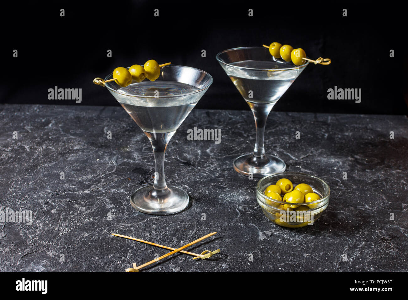 Martini cocktail with green olives on stone table background Stock ...