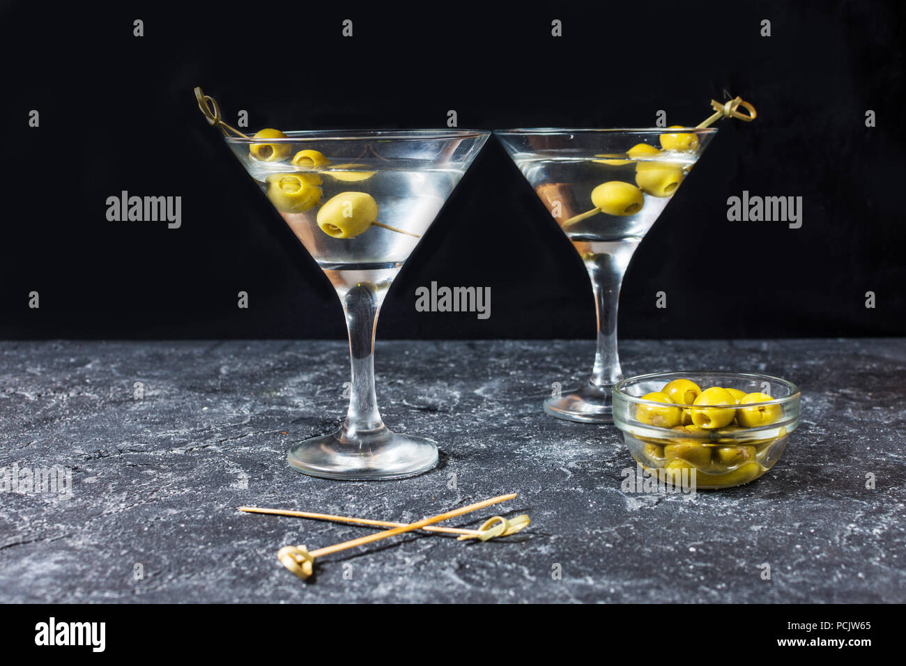Martini cocktail with green olives on stone table background Stock ...