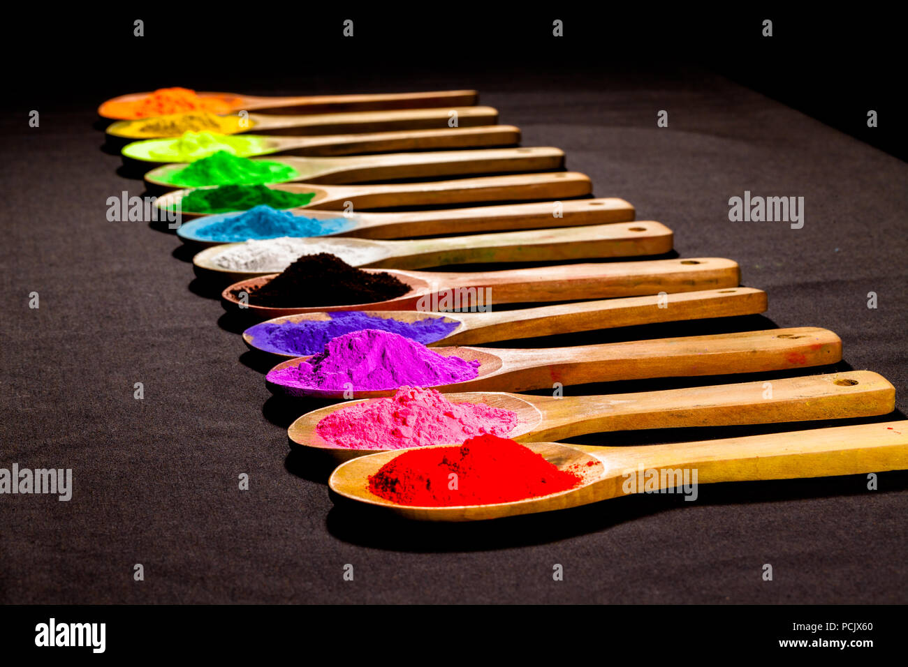 a row of colourful powder paint on black fabric. colourful powder paint ...