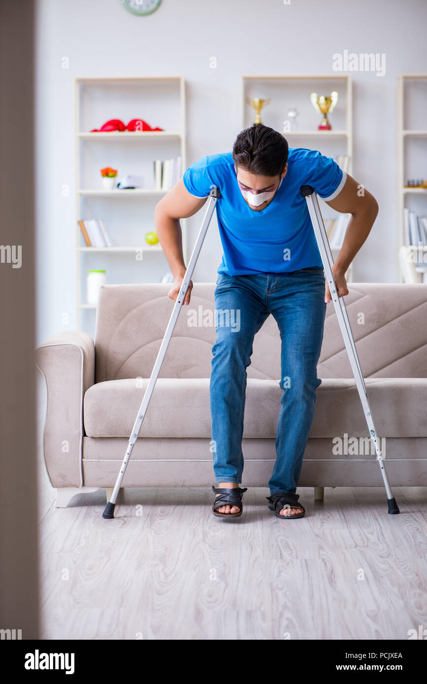 Injured man with crutches recovering at home Stock Photo - Alamy