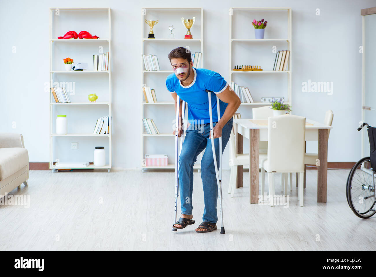 Injured man with crutches recovering at home Stock Photo - Alamy