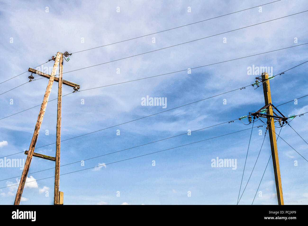 Old power poles against a blue sky Stock Photo - Alamy
