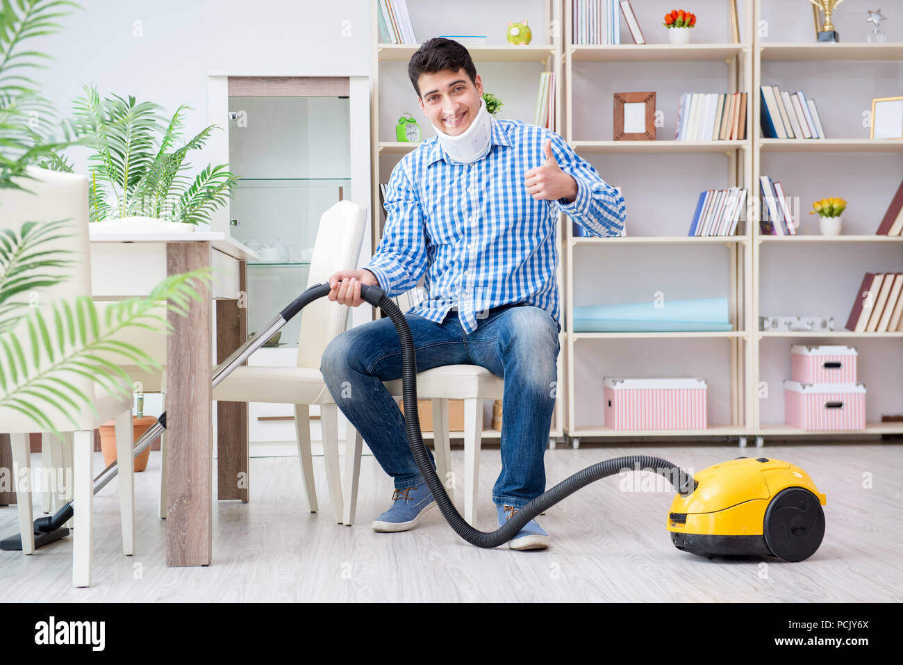 Injured man with neck injury vacuum cleaning house Stock Photo - Alamy