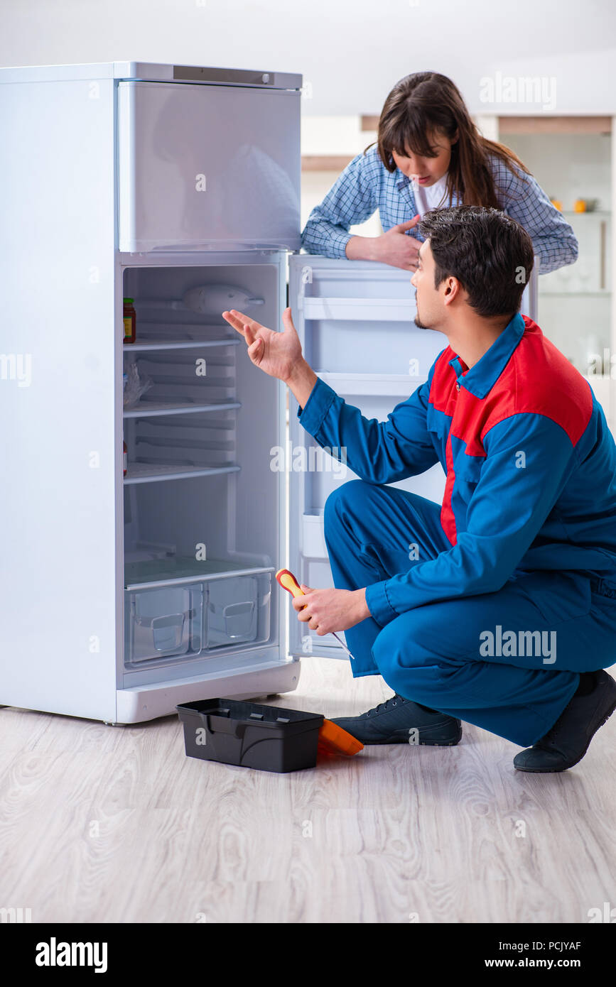 Man repairing fridge with customer Stock Photo - Alamy