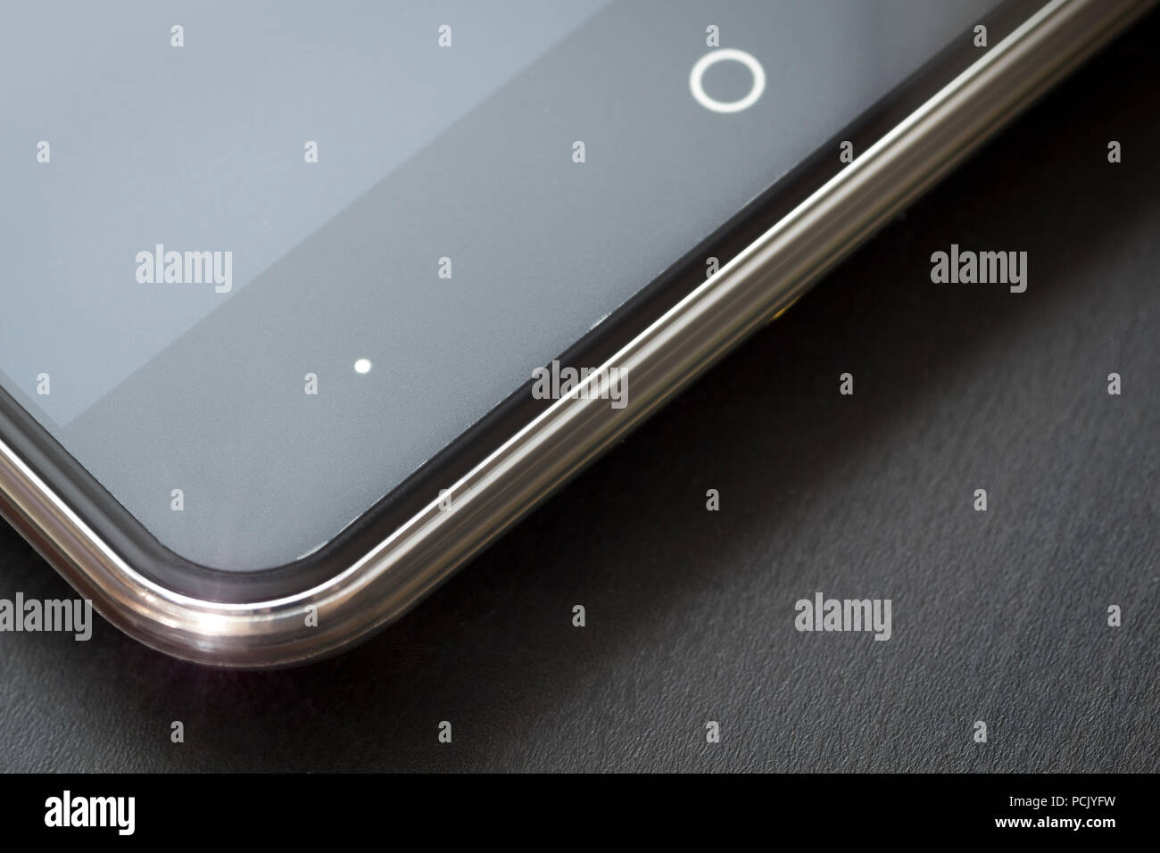 A smartphone rests on a black office desk close-up Stock Photo - Alamy