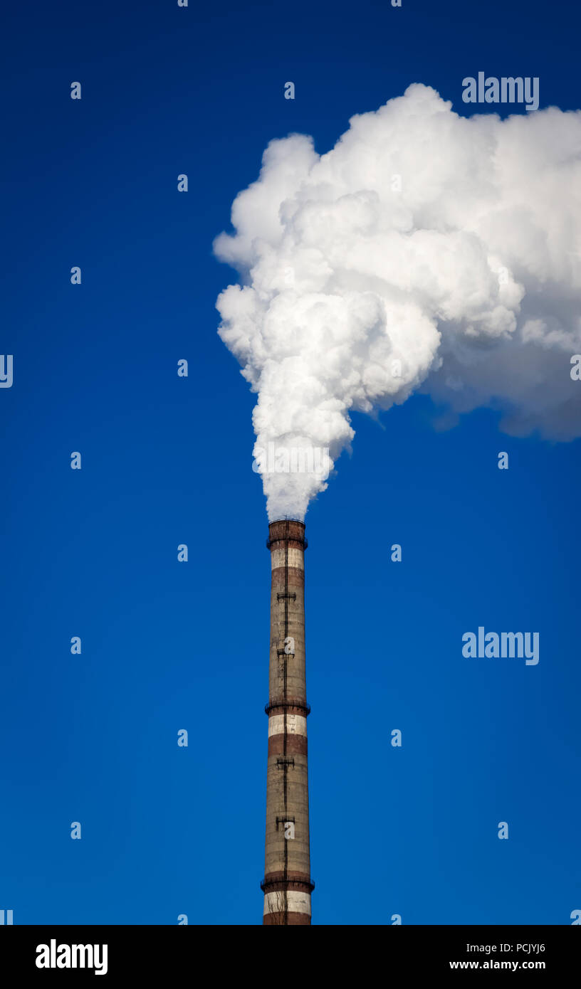 The thick smoke rises high from the industrial pipes. Pollution of the ...