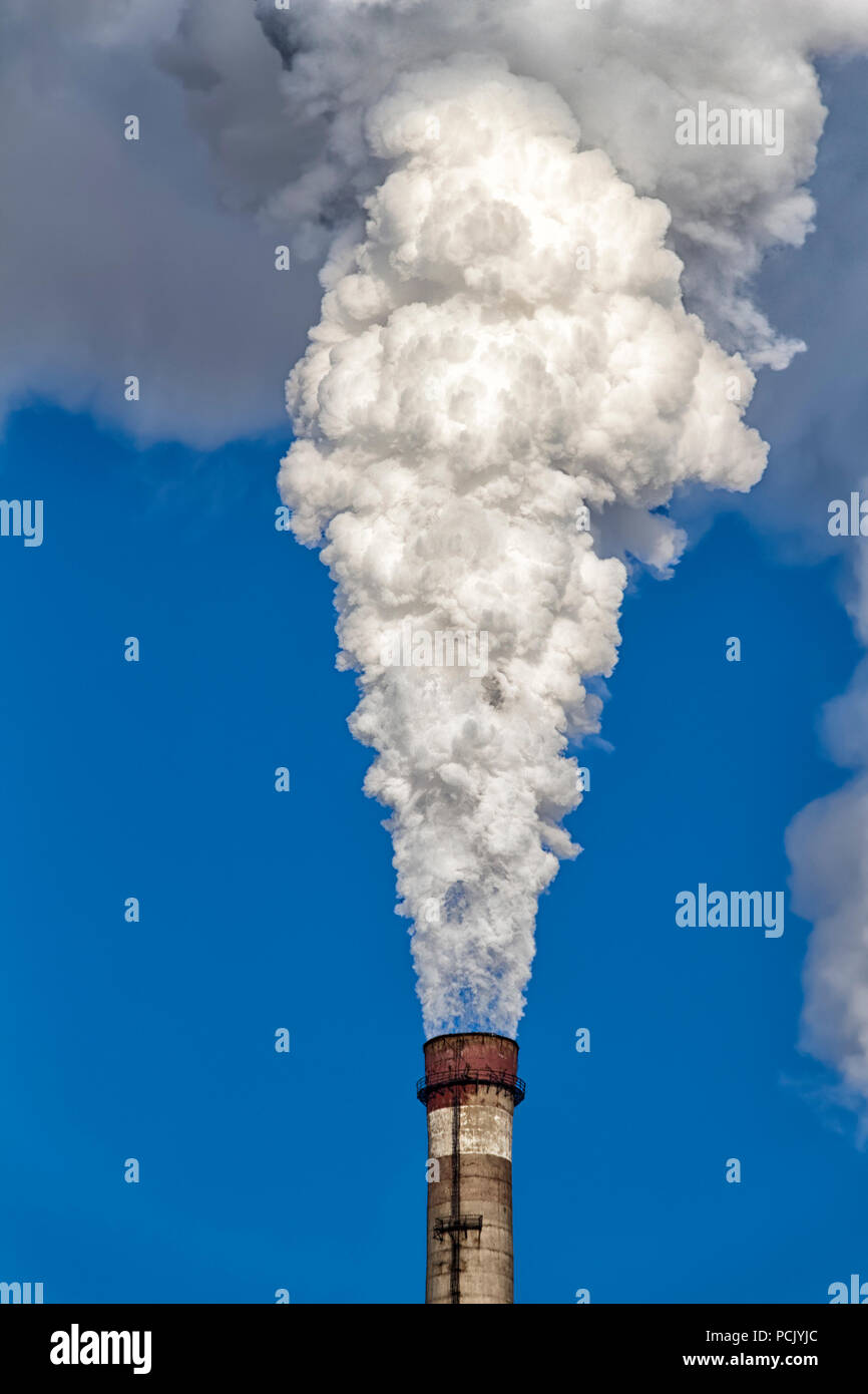 The thick smoke rises high from the industrial pipes. Pollution of the ...